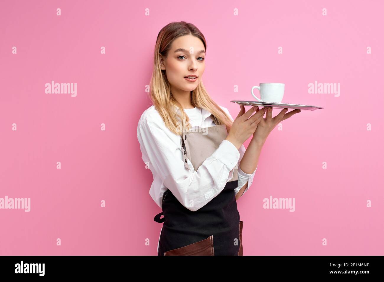 nice woman waitress in apron, offering cup of delicious tasty coffee ...