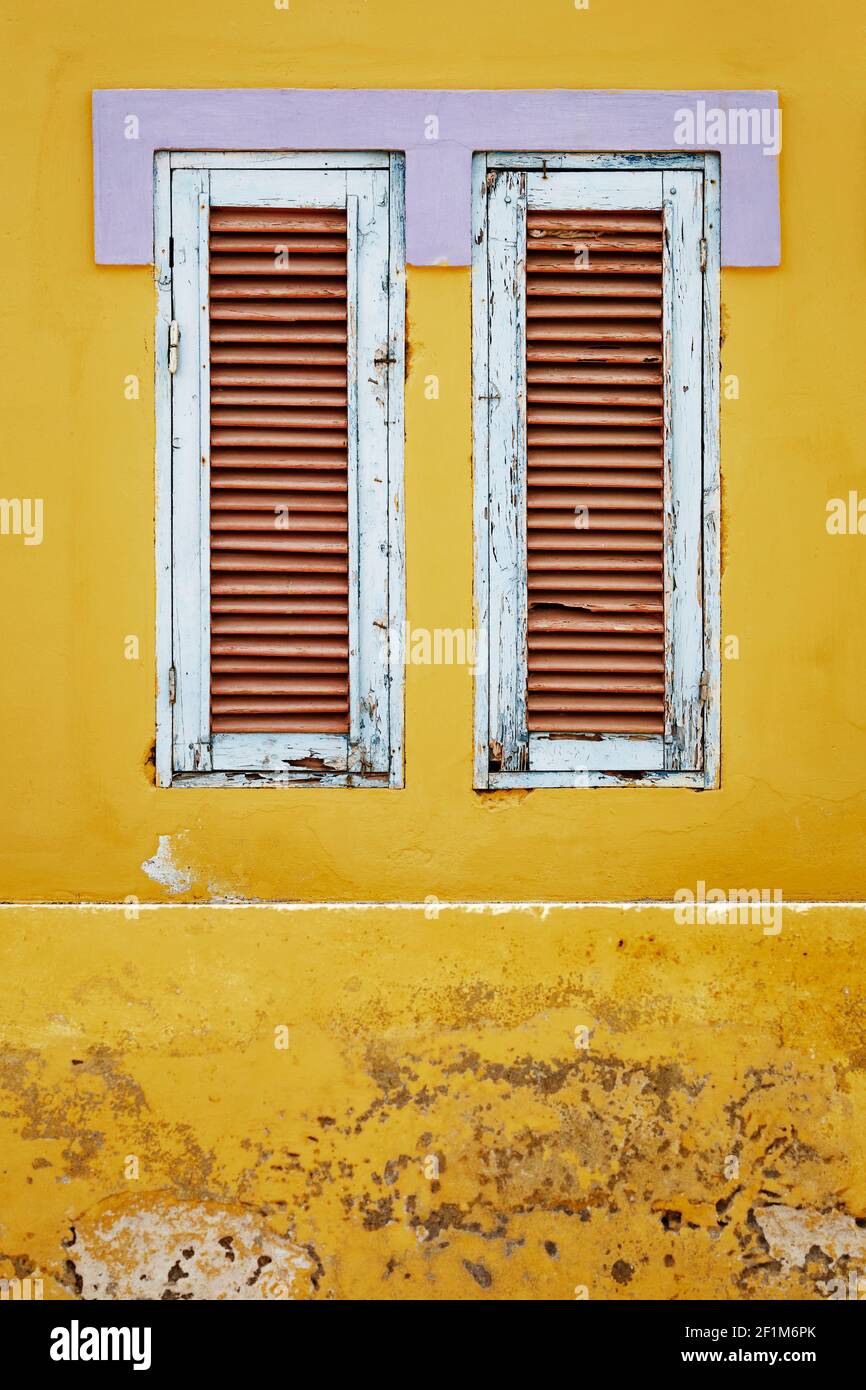 Yellow wall with close window shutters Stock Photo - Alamy