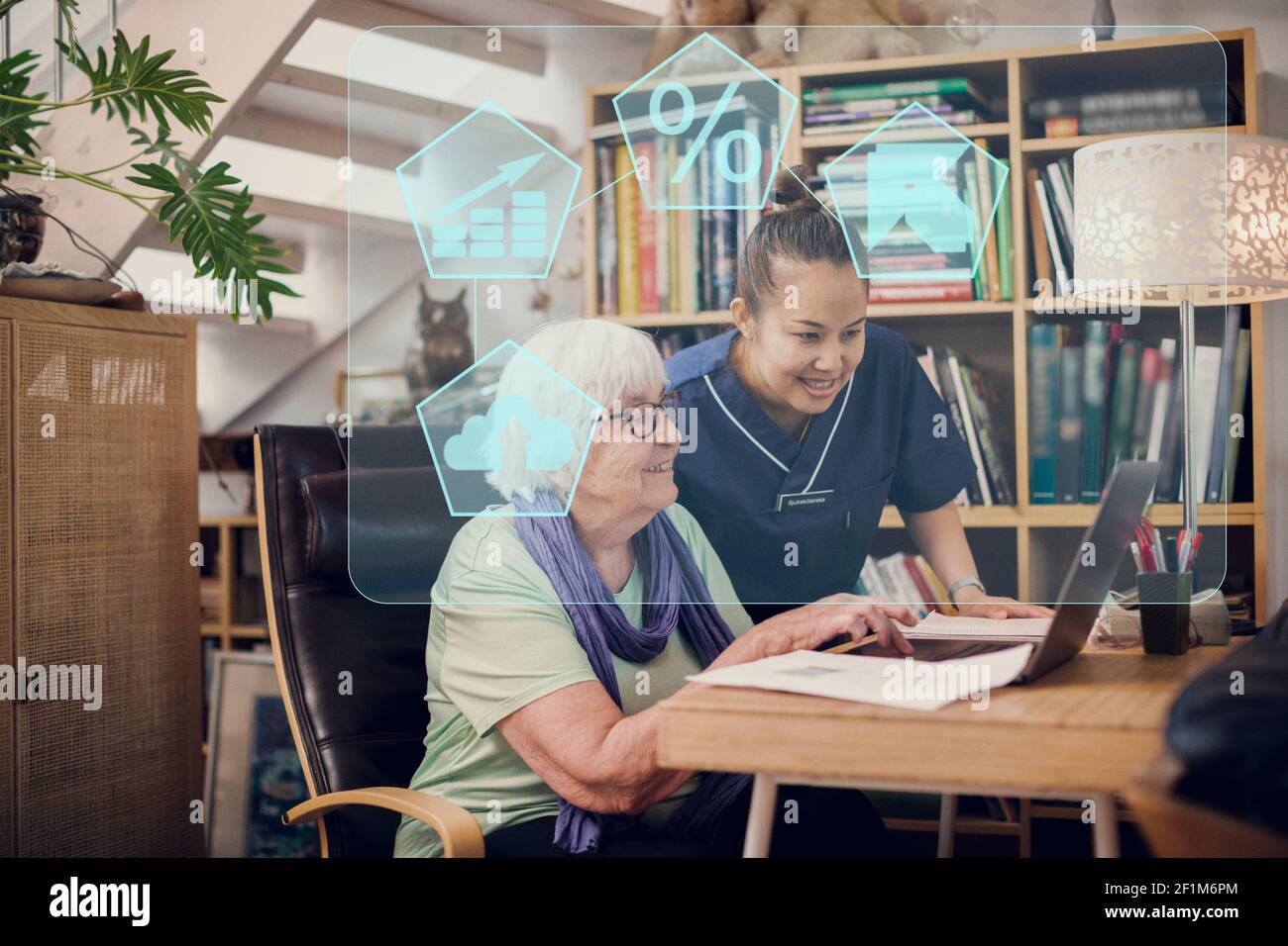 Home carer helping senior woman to use laptop Stock Photo - Alamy