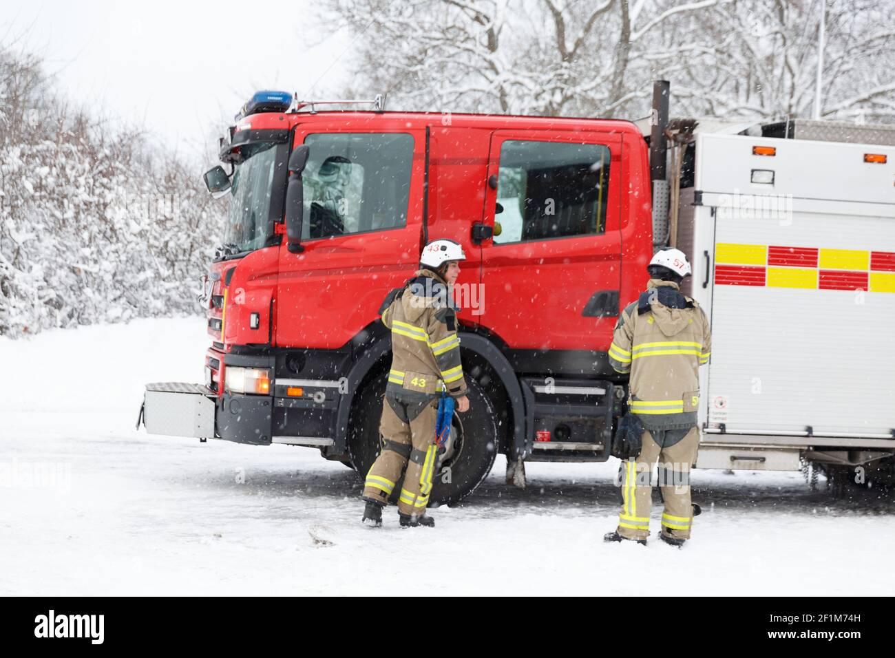 Firefighters in front of fire engine at winter Stock Photo - Alamy