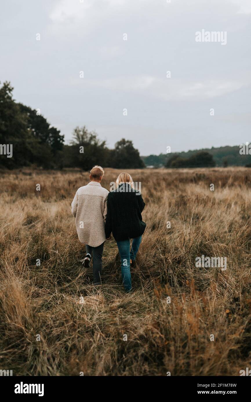 Female couple walking through meadow Stock Photo - Alamy