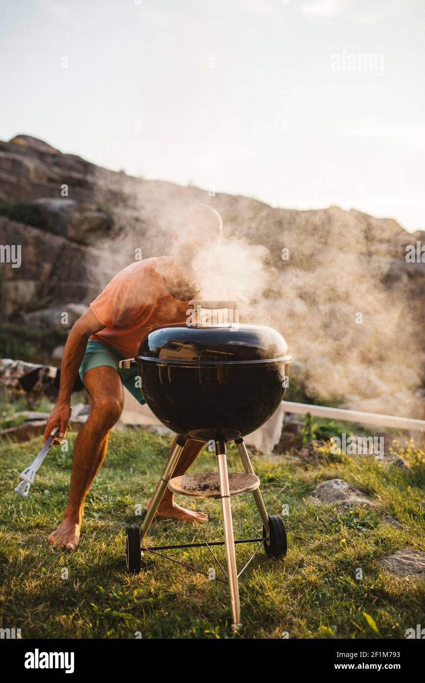 Man having barbecue in garden Stock Photo - Alamy