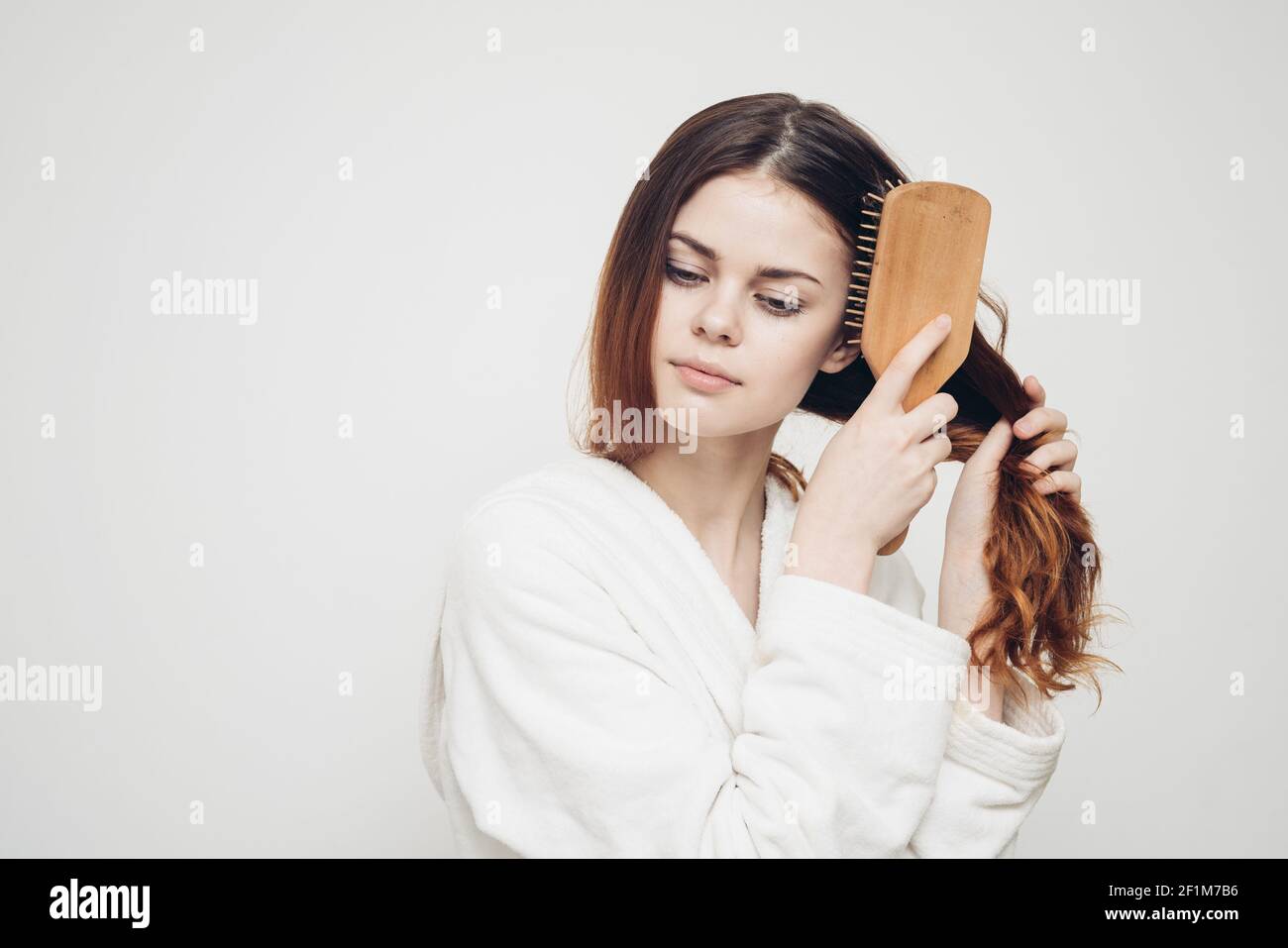 Woman in a white robe with a wooden comb and long hair model Stock ...