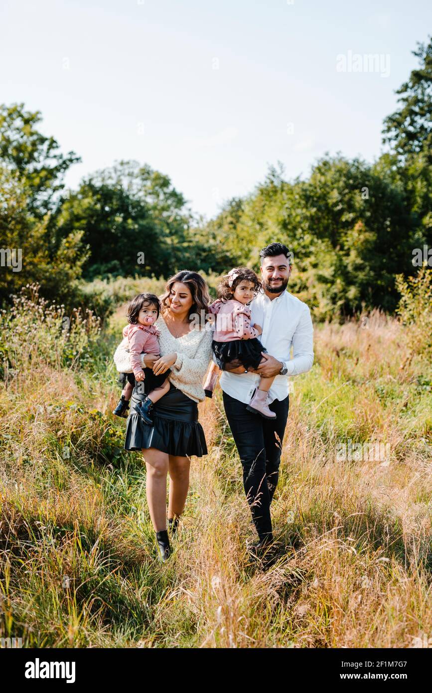 Parents with two daughters walking Stock Photo - Alamy