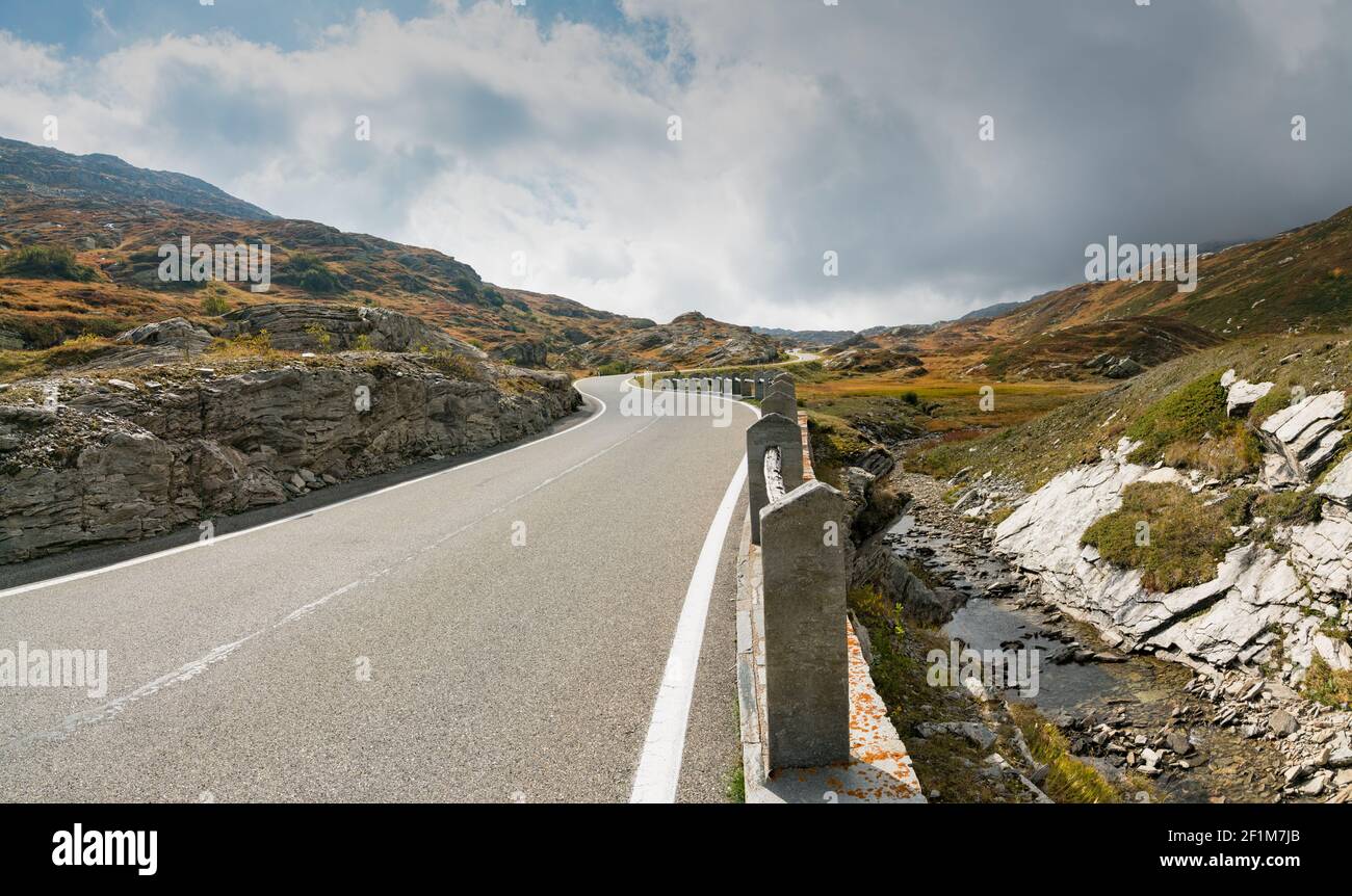 Two-lane road leading over a high remote and wild mountain pass in the ...