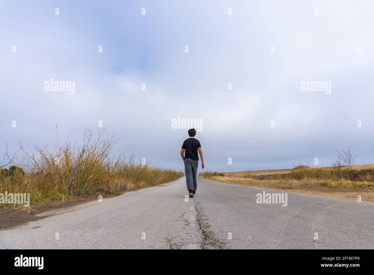Stock photo of faceless person walking in a road surrounded by the ...