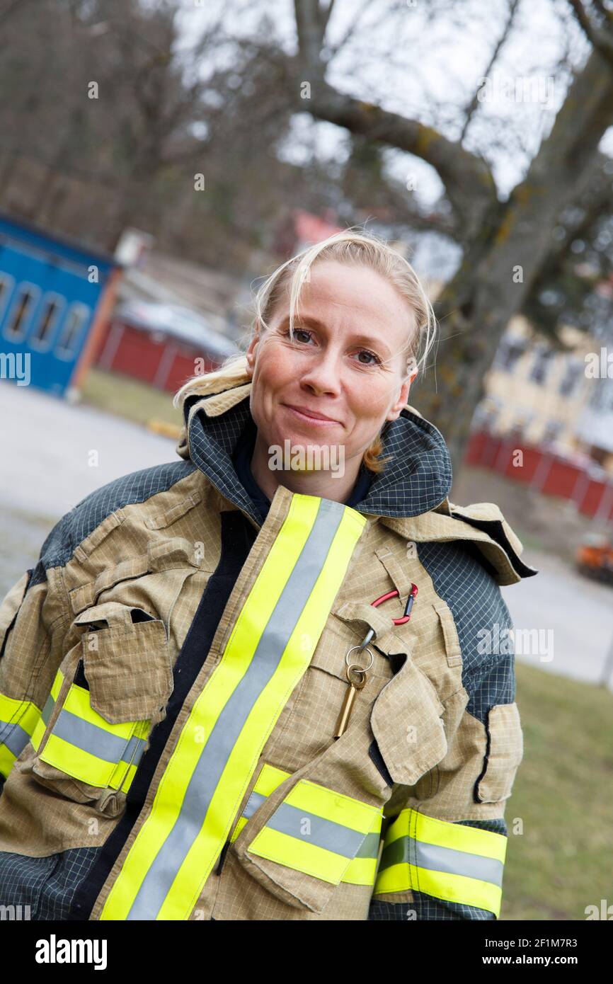Smiling female firefighter looking at camera Stock Photo - Alamy