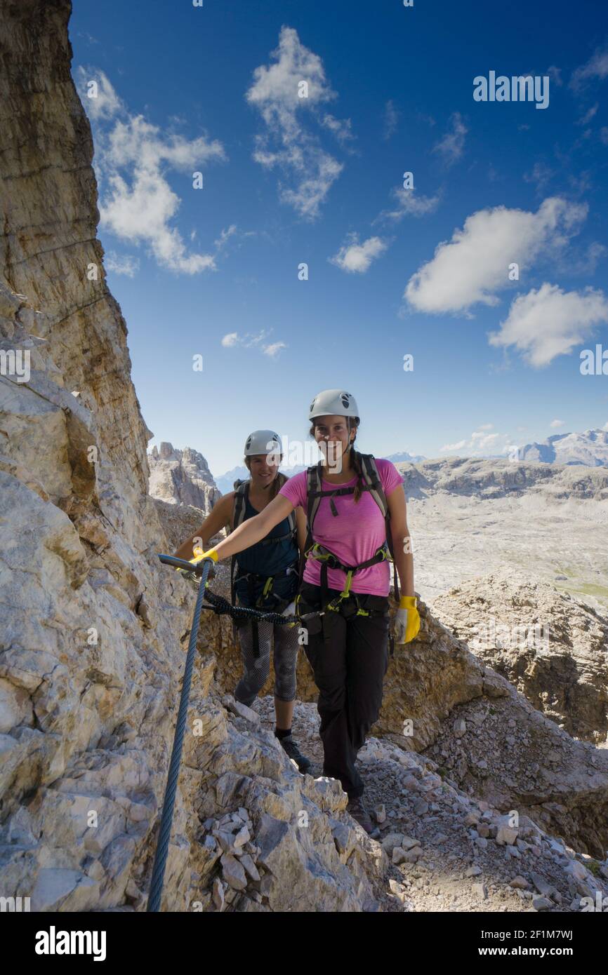 Attractive female climbers on a steep Via Ferrata in the Italian ...