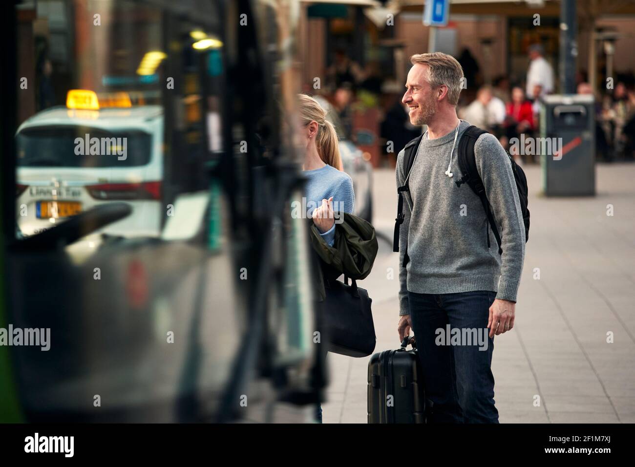 Smiling man seen from behind bus Stock Photo - Alamy