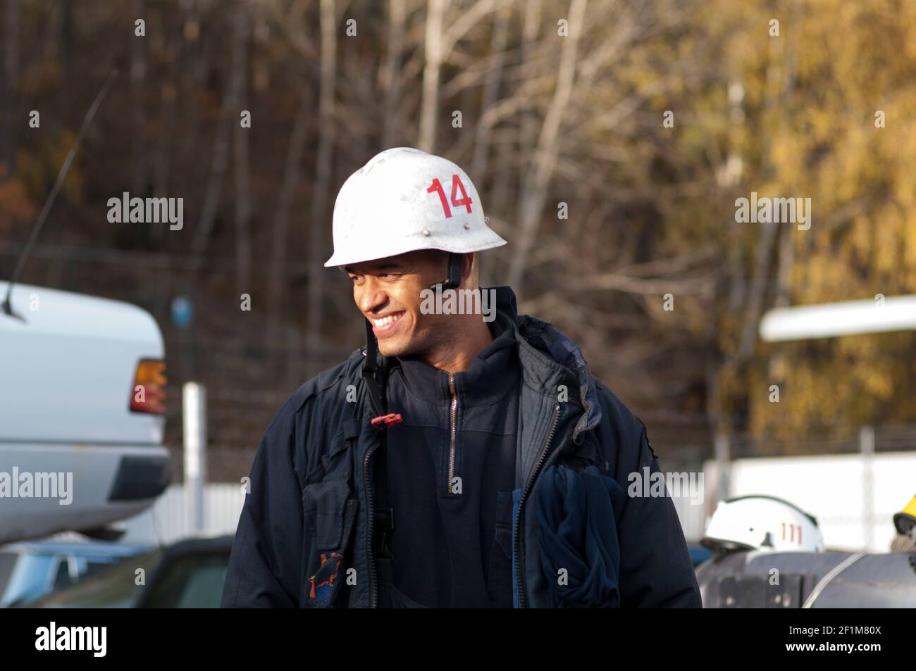 Smiling firefighter looking away Stock Photo - Alamy