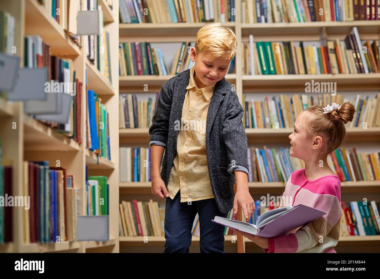 school kids preparing for lesson in school library, reading textbooks ...