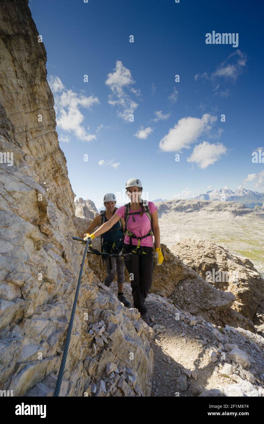 Attractive female climbers on a steep Via Ferrata in the Italian ...
