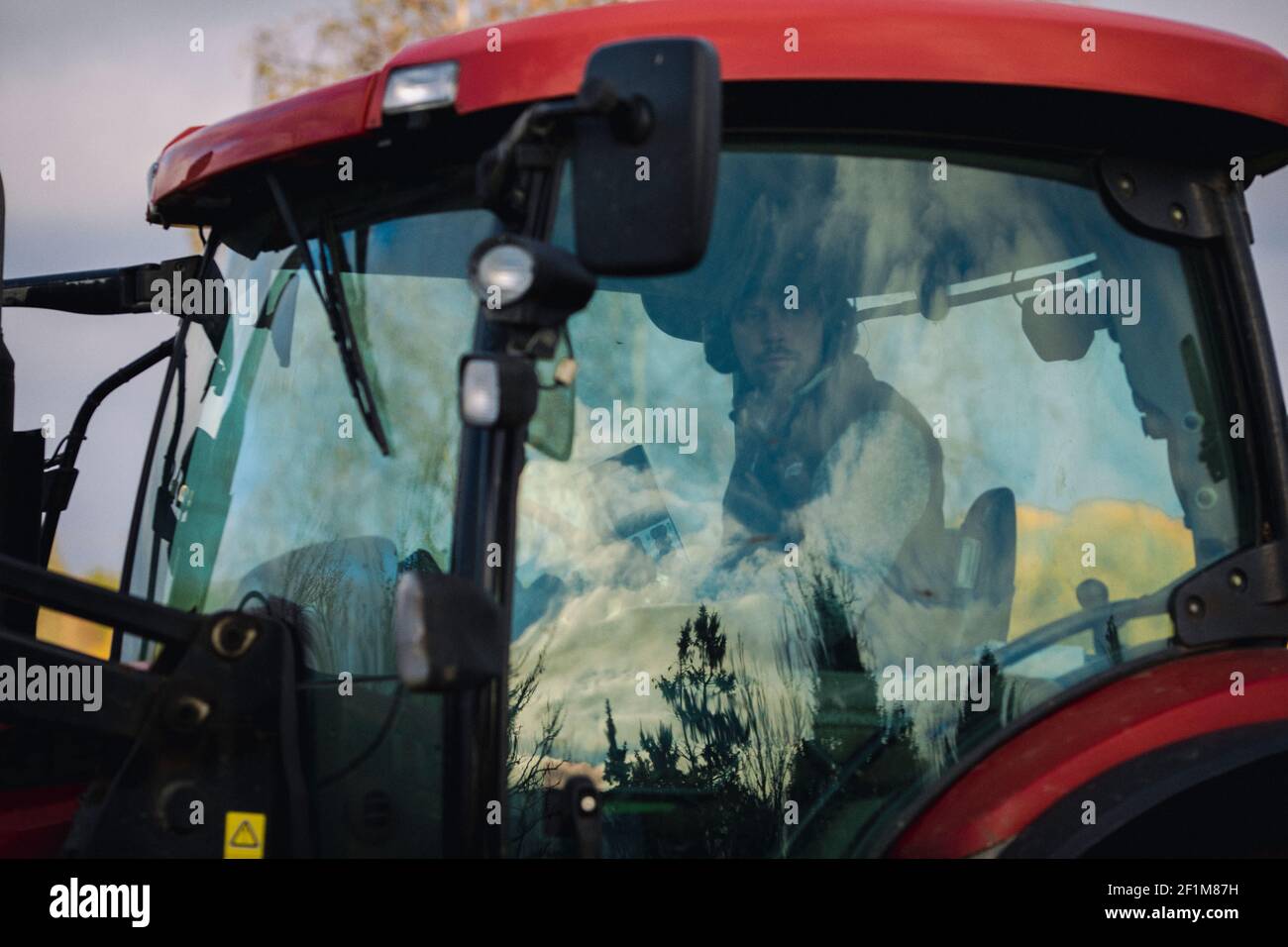 Farmer driving tractor Stock Photo - Alamy