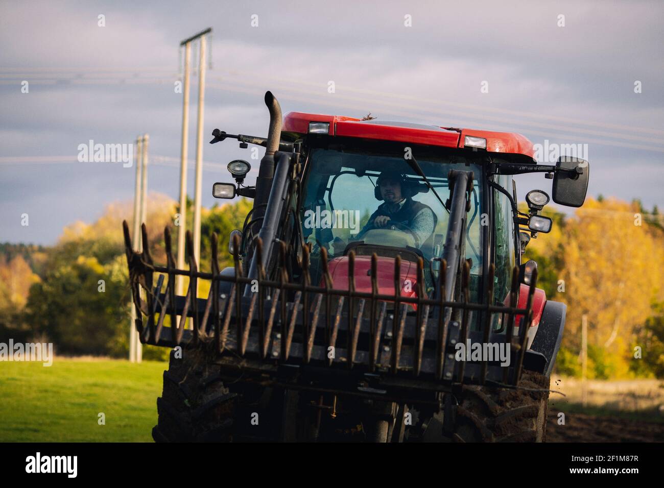 Farmer driving tractor Stock Photo - Alamy