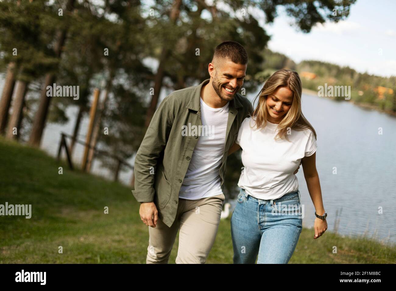 Smiling couple walking at lake Stock Photo - Alamy