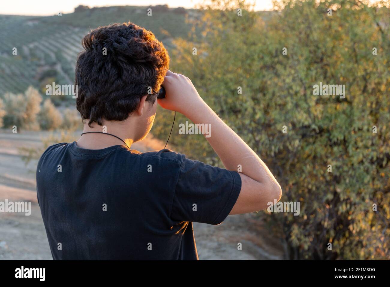 Stock photo of faceless boy using binoculars in the countryside for ...