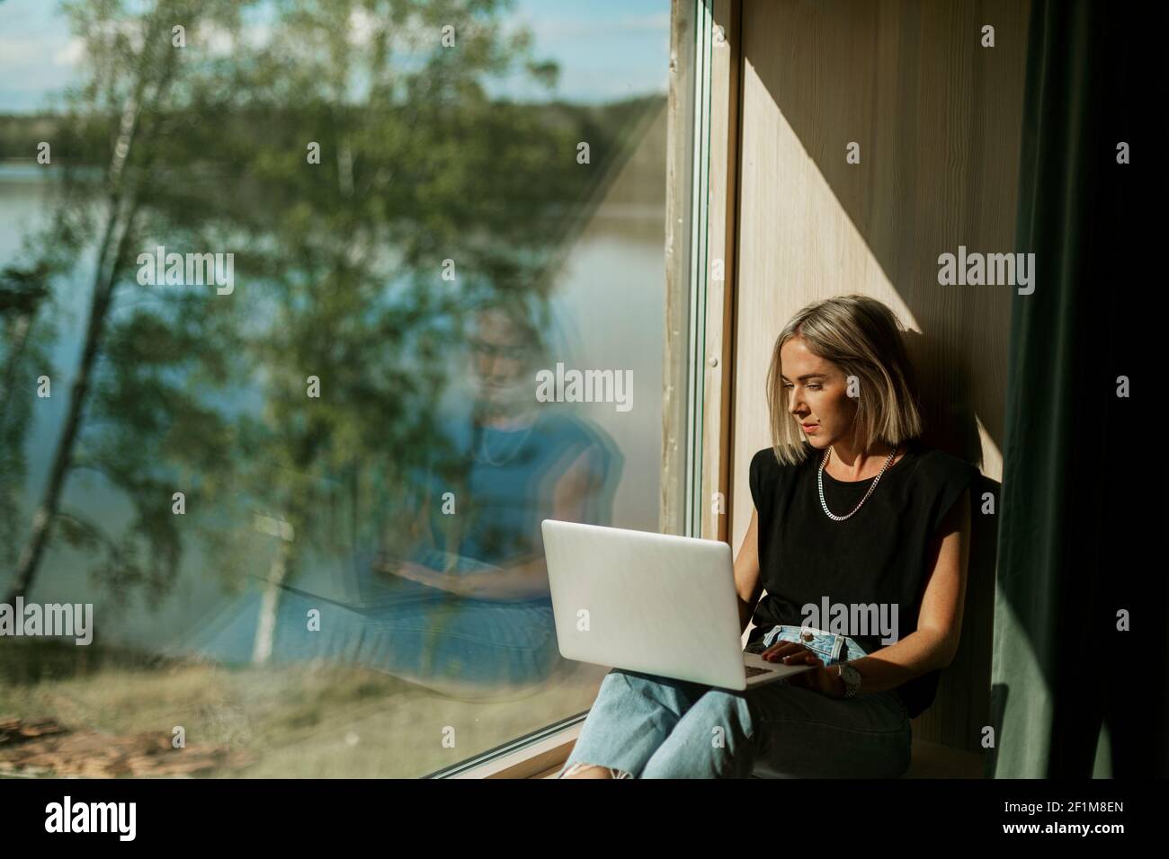 Woman using laptop by the sea hi-res stock photography and images - Alamy