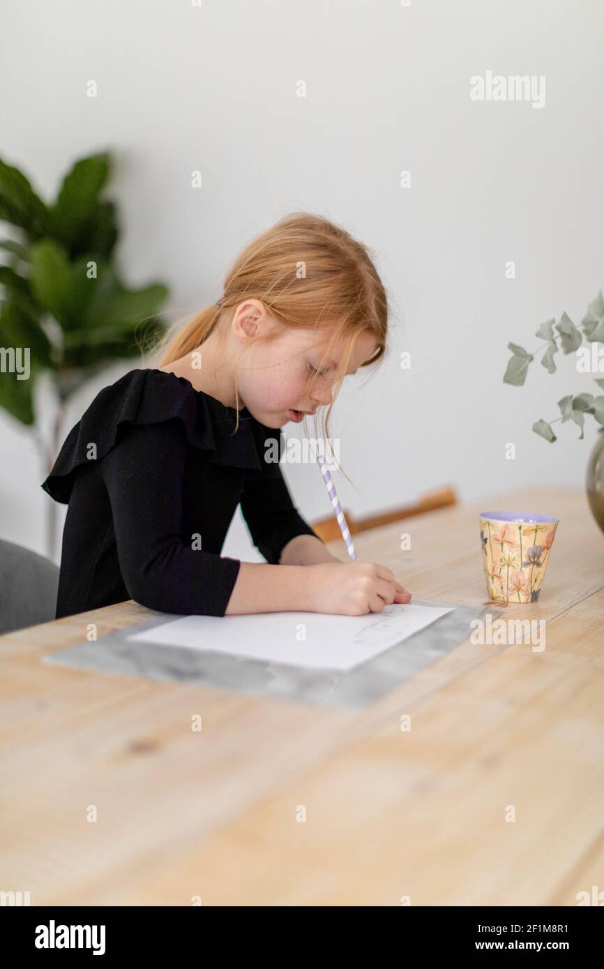 Girl doing homework table hi-res stock photography and images - Alamy