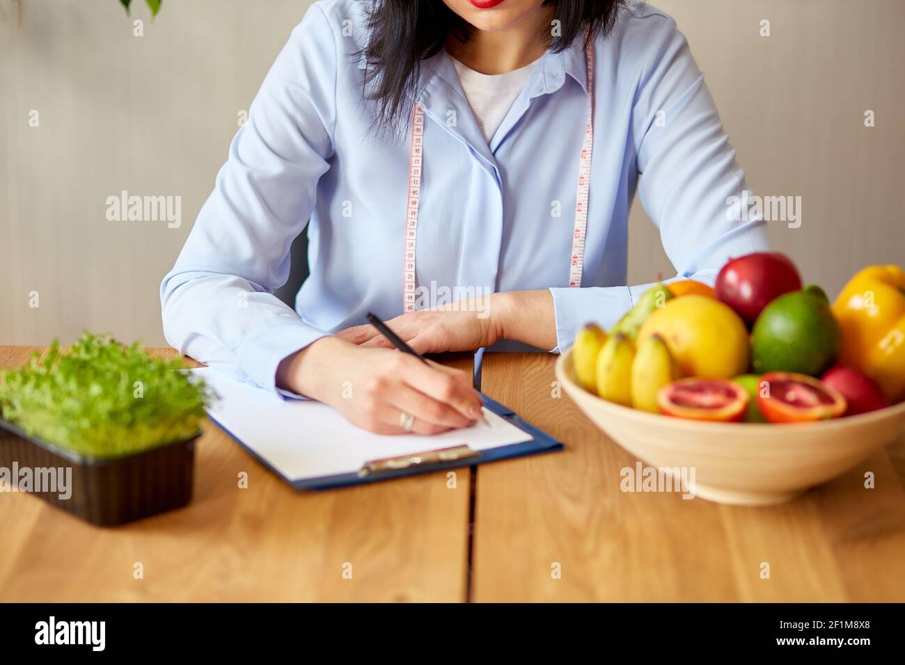 Nutritionist, dietitian woman writing a diet plan, with healthy ...