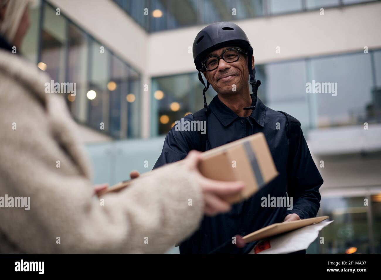 Bicycle courier delivering parcel to client Stock Photo - Alamy