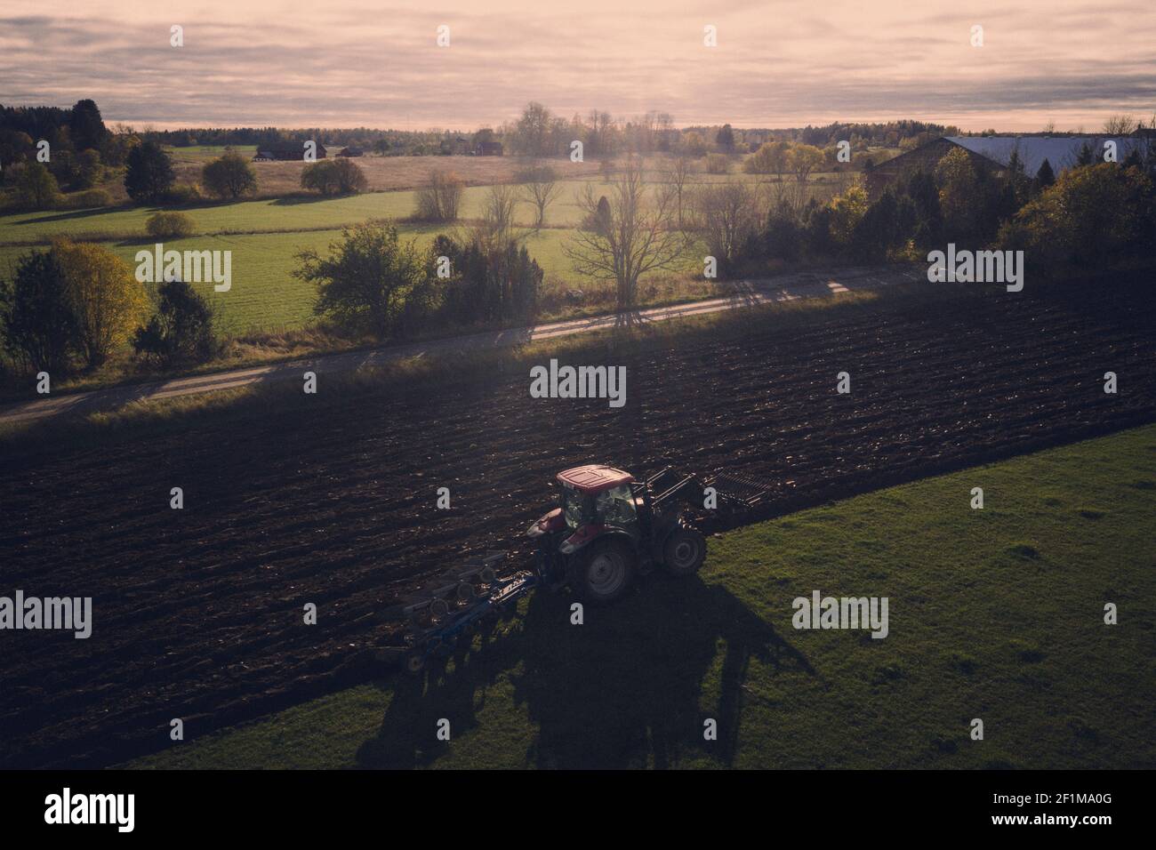 Tractor plowing field at autumn Stock Photo - Alamy