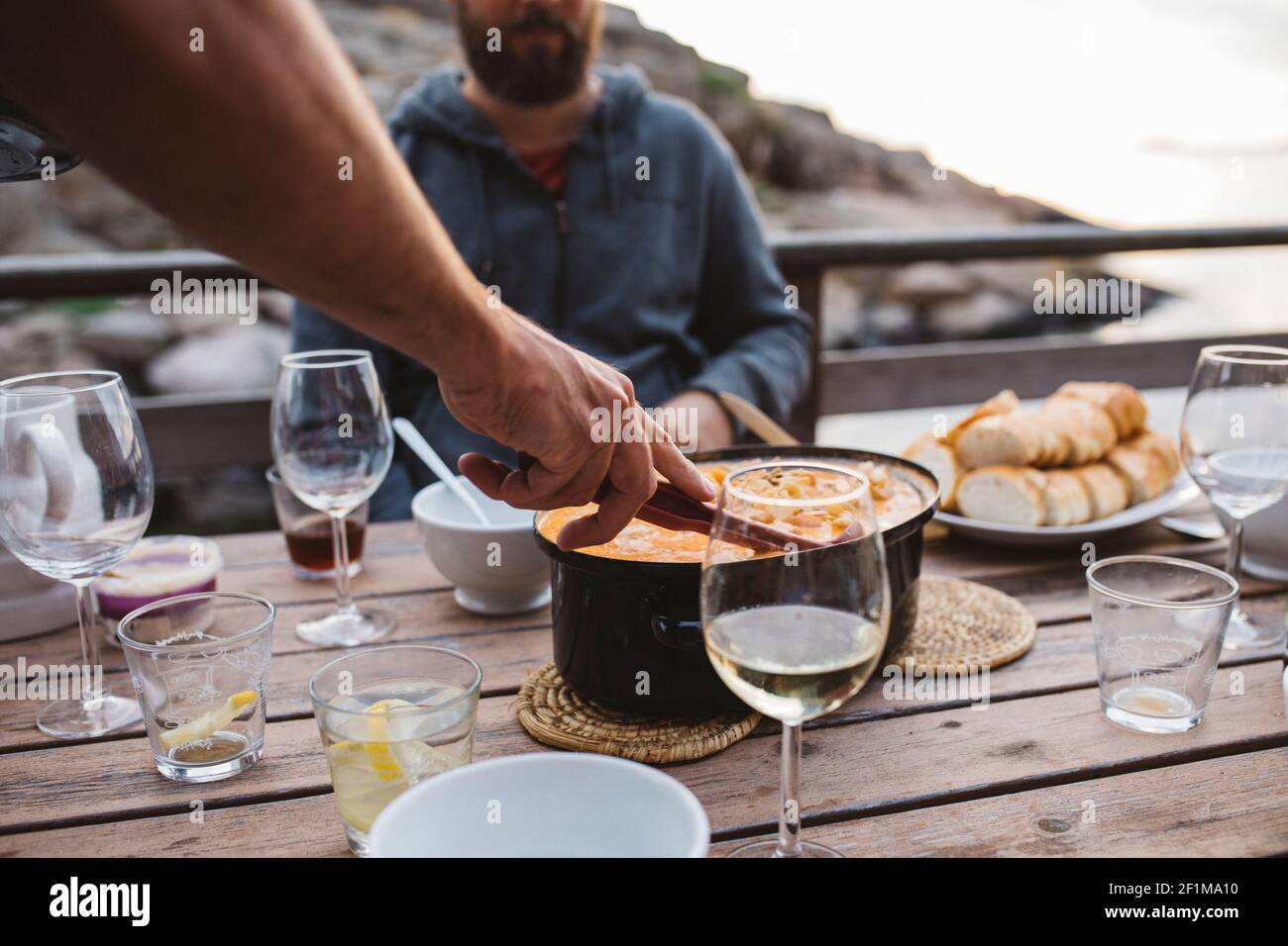 Hand taking food out of dish Stock Photo - Alamy