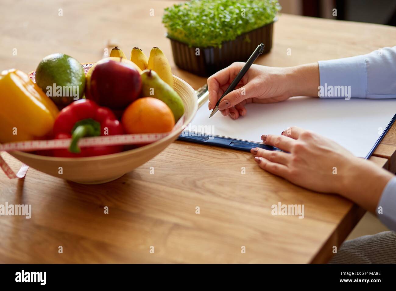 Nutritionist, dietitian woman writing a diet plan, with healthy ...