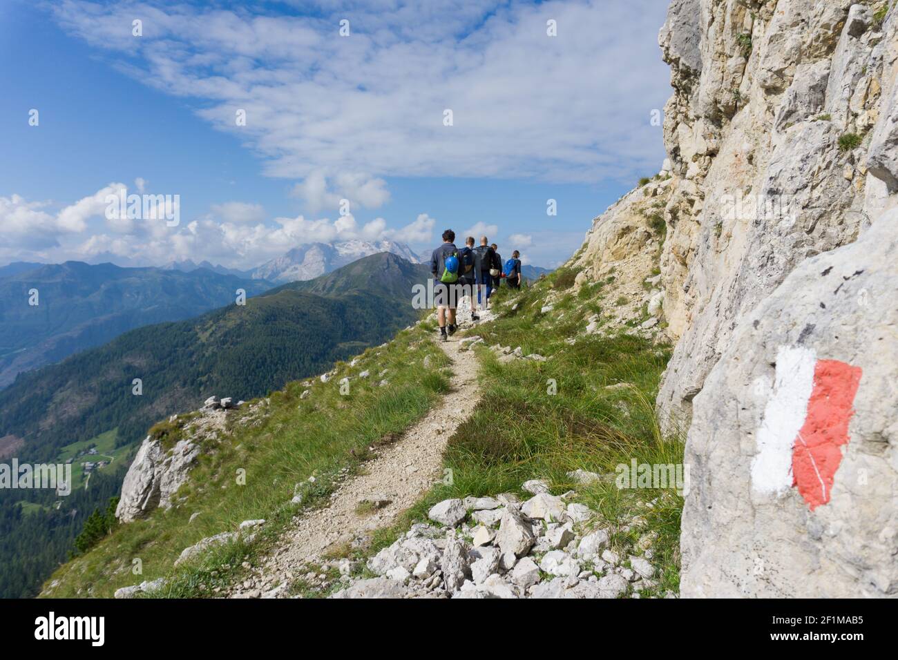 Group of mountain climbers hiking up a mountain side to a hard climbing ...