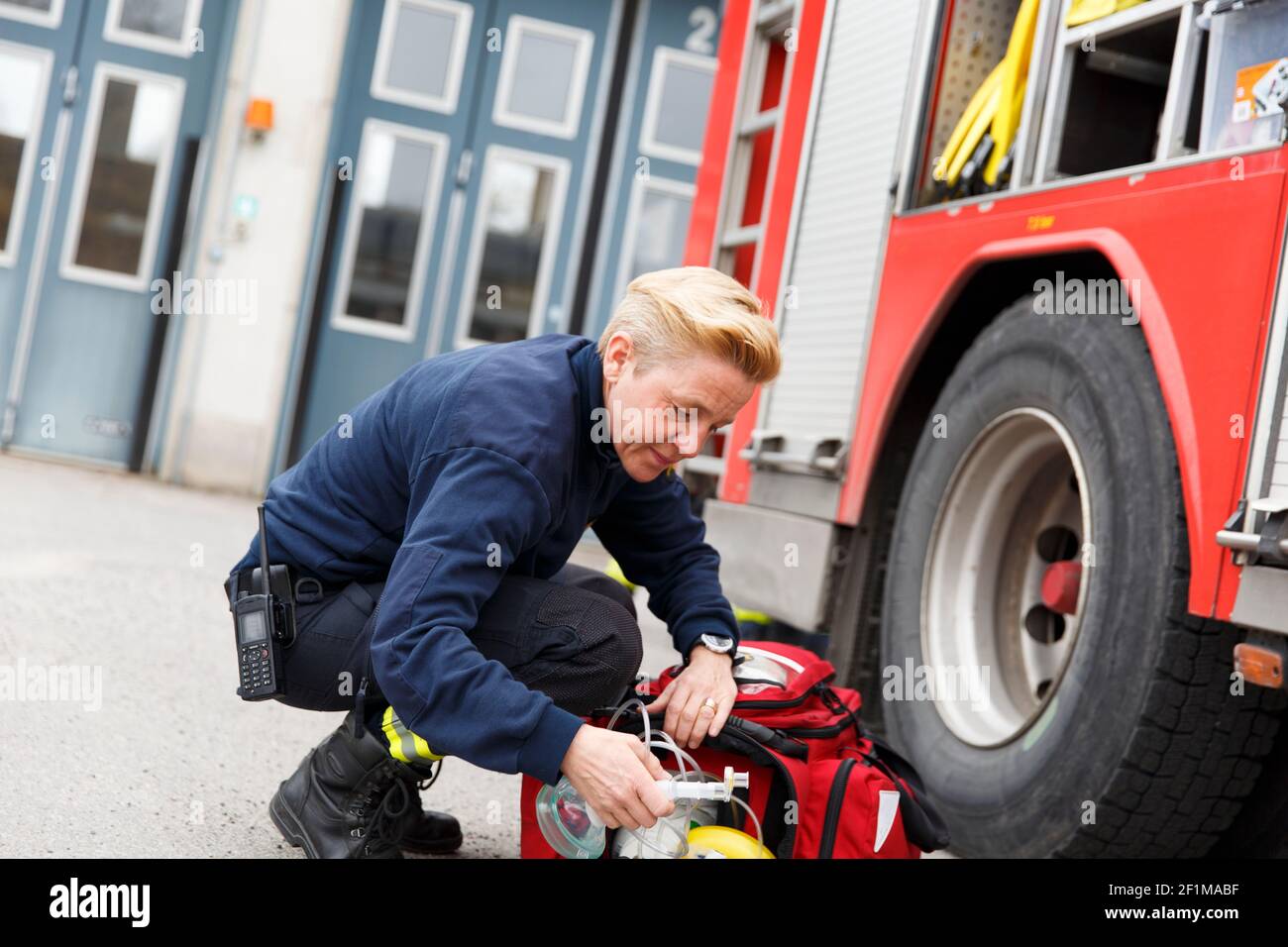 Female firefighter checking equipment Stock Photo - Alamy