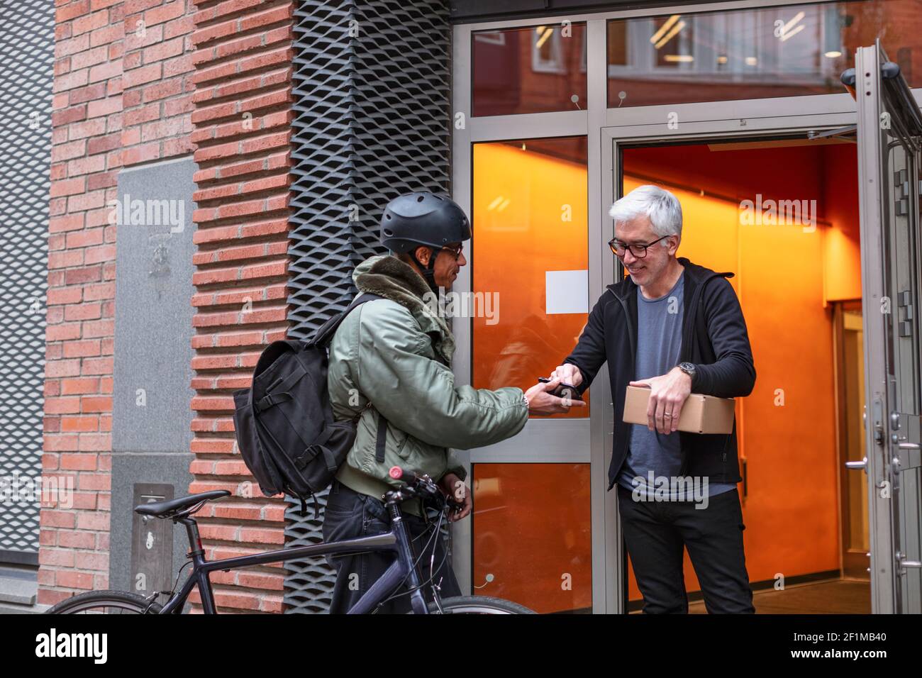 Man signing delivery Stock Photo - Alamy