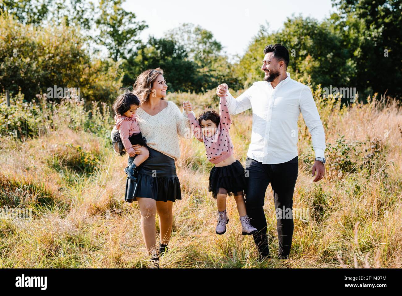 Parents with two daughters walking Stock Photo - Alamy