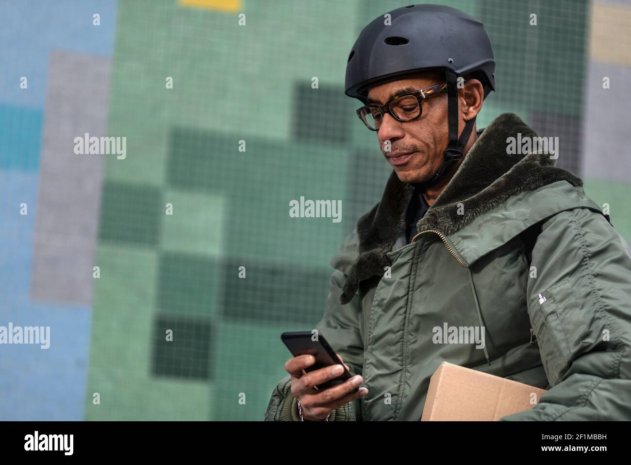 Bicycle courier using cell phone Stock Photo - Alamy