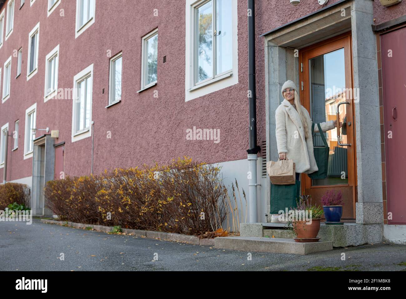 Woman entering building Stock Photo - Alamy