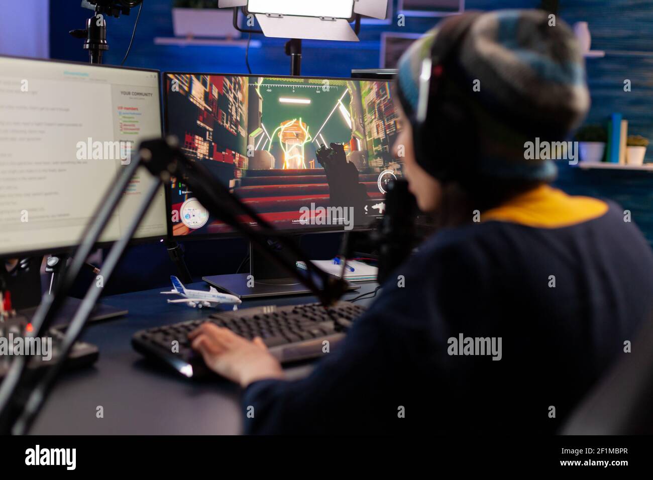 Pro gamer sitting on gaming chair at desk and talking into microphone ...