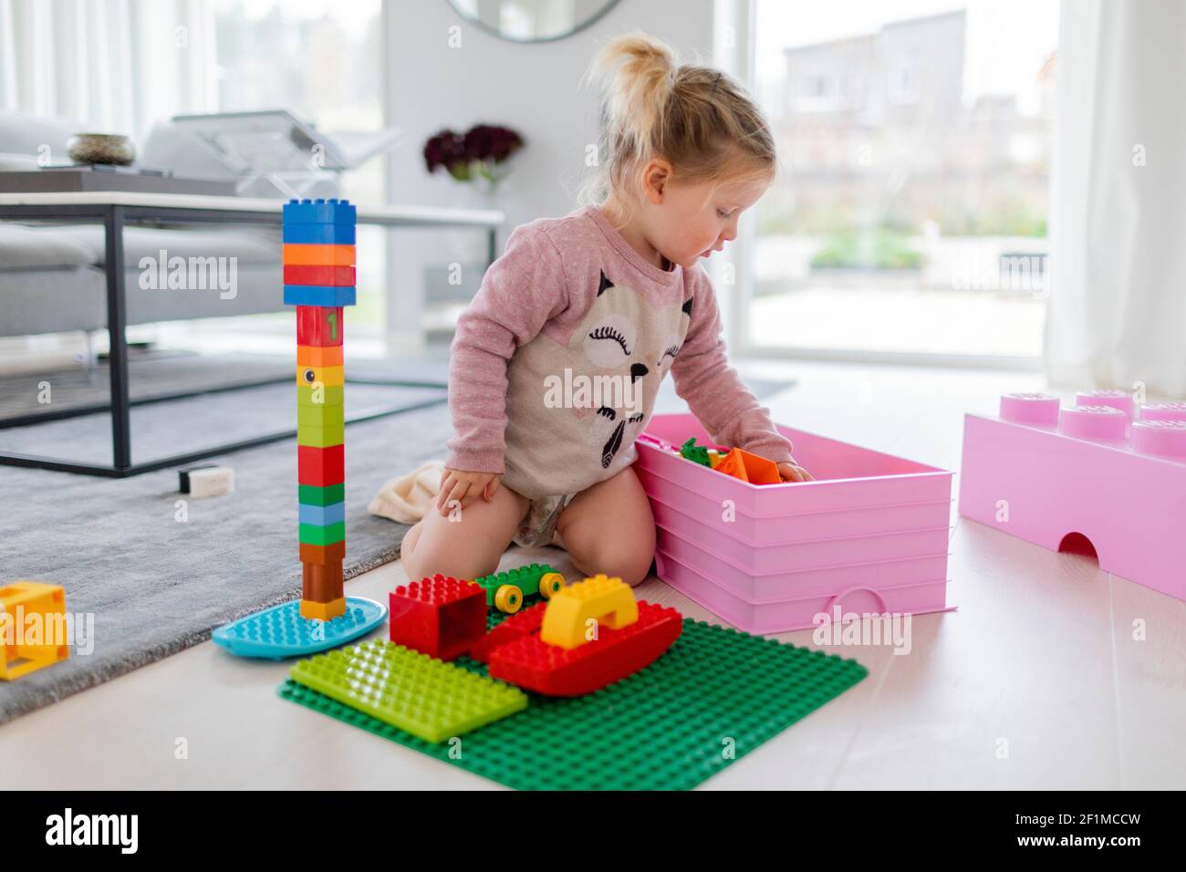Toddler girl playing with building blocks Stock Photo - Alamy