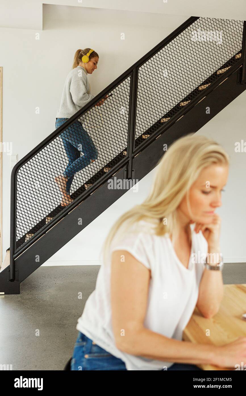 Woman walking upstairs Stock Photo - Alamy