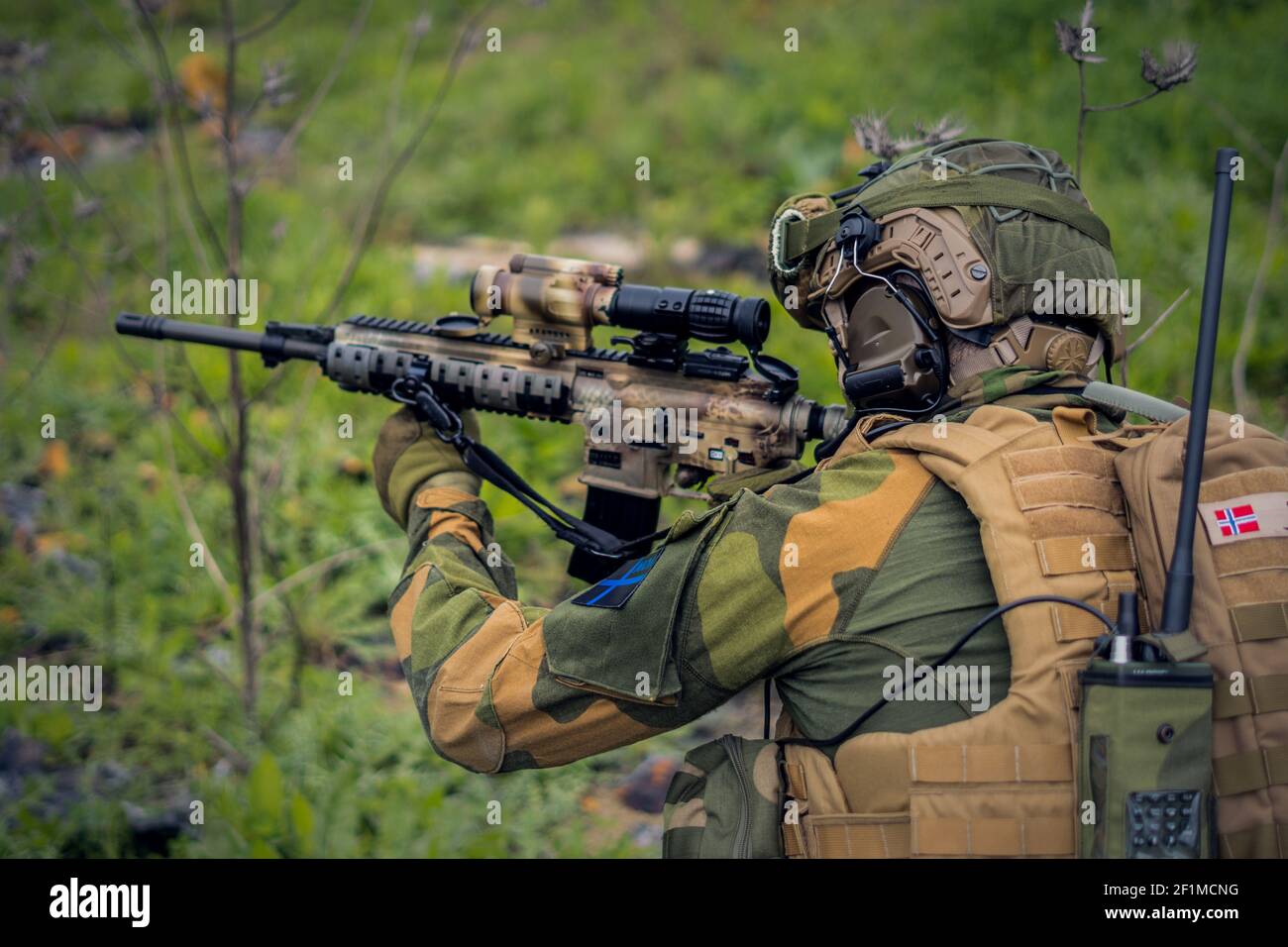 A side view of a special forces soldier aiming with an assault rifle ...