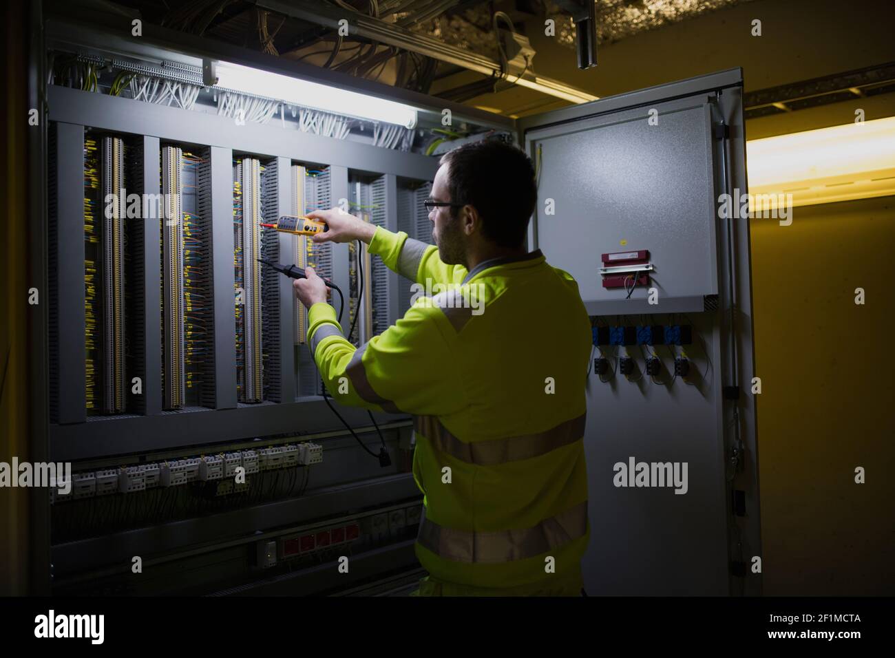 Electrician working at electric panel Stock Photo - Alamy