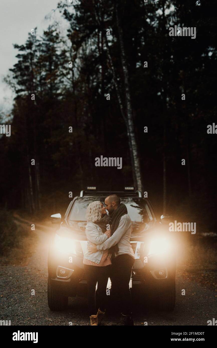 Couple kissing in front of car Stock Photo - Alamy