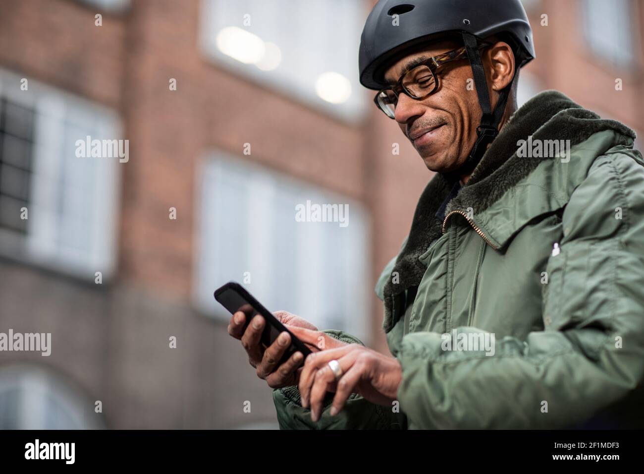 Bicycle courier using cell phone Stock Photo - Alamy