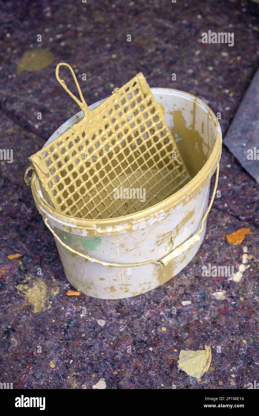 Bucket of yellow color and scraper Stock Photo - Alamy