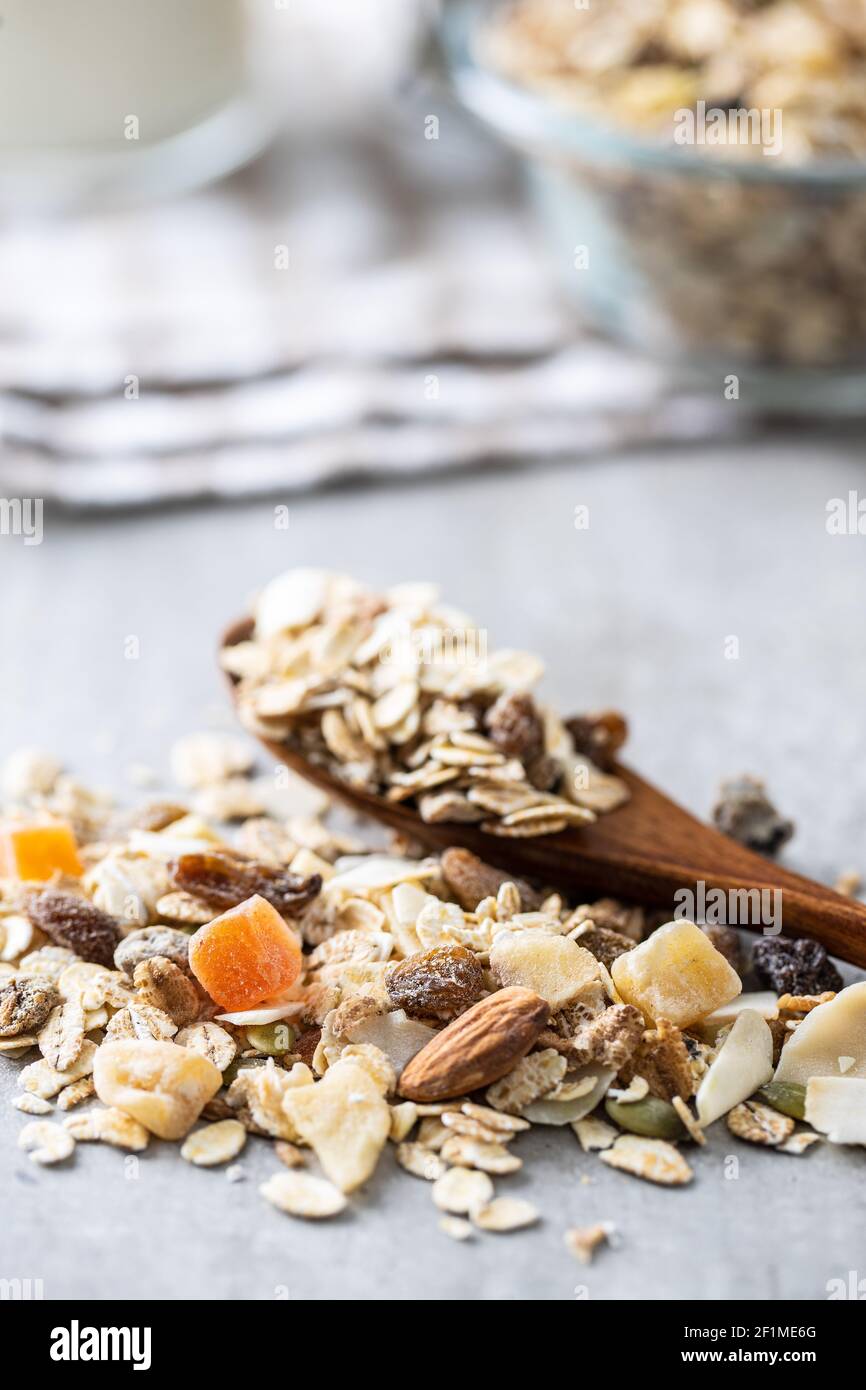 Beakfast cereals in wooden scoop. Healthy muesli with oat flakes, nuts ...