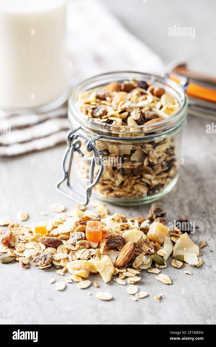 Beakfast cereals on kitchen table. Healthy muesli with oat flakes, nuts ...