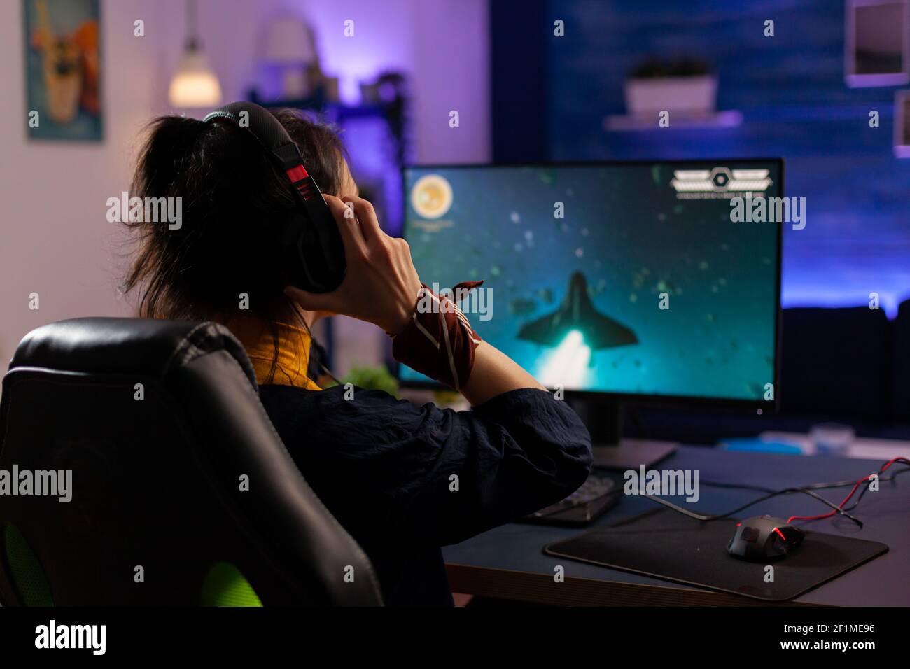 Focused Gamer puts professional headphones and playing space shooter ...
