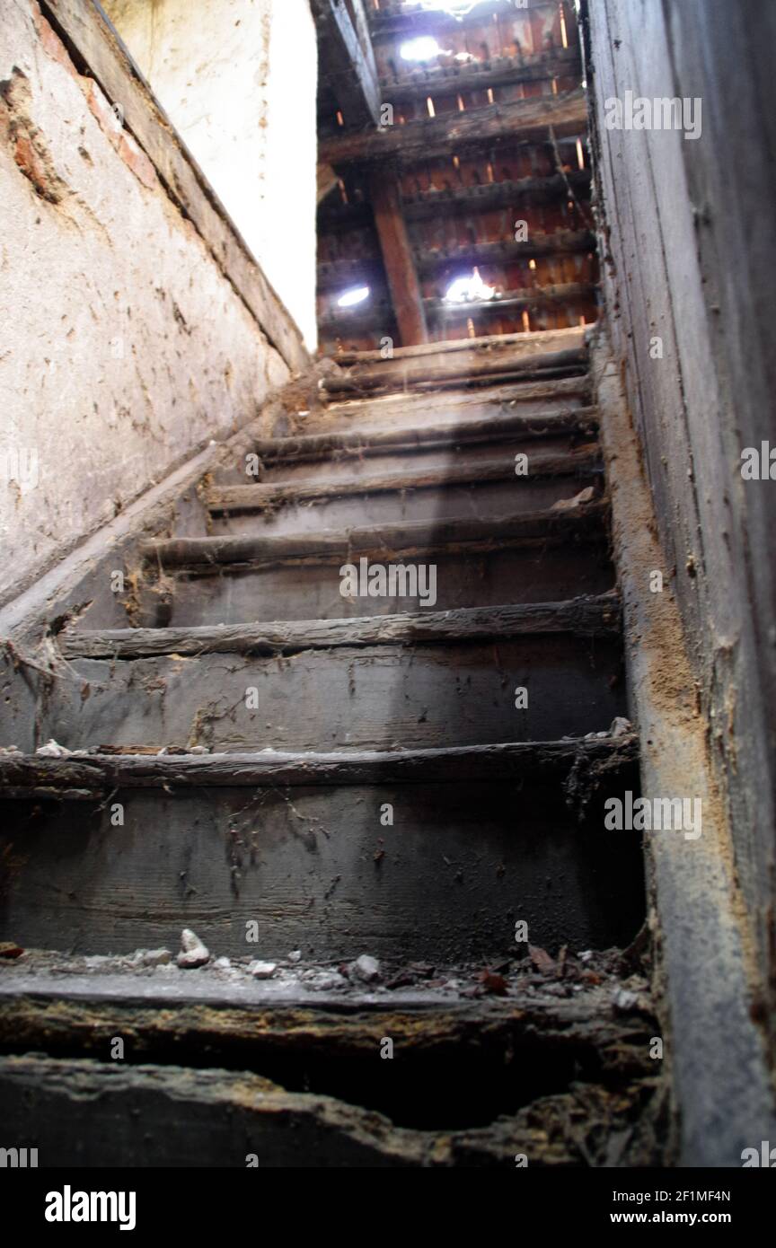 Old attic stairs in a ruined building. A dark and mysterious corner of ...