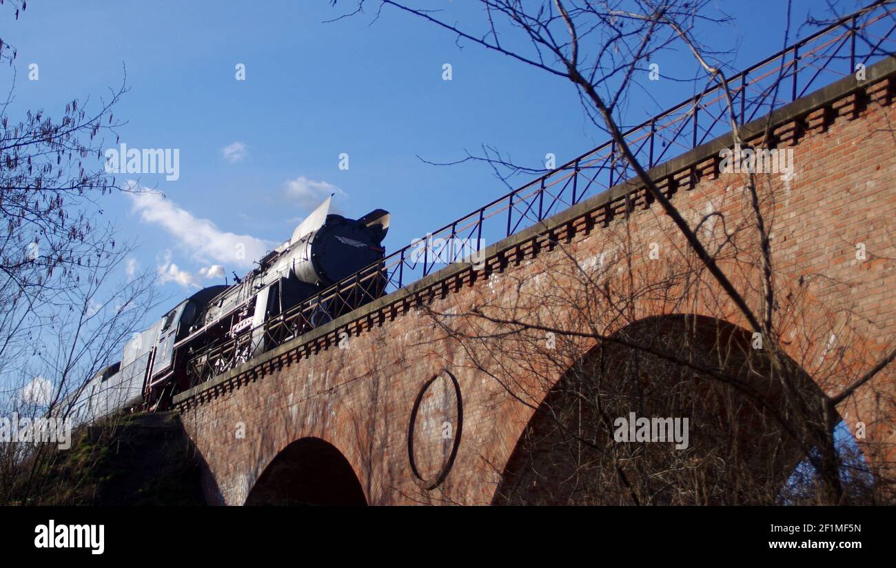 Steam locomotive on the old brick bridge. Retro passenger transport ...