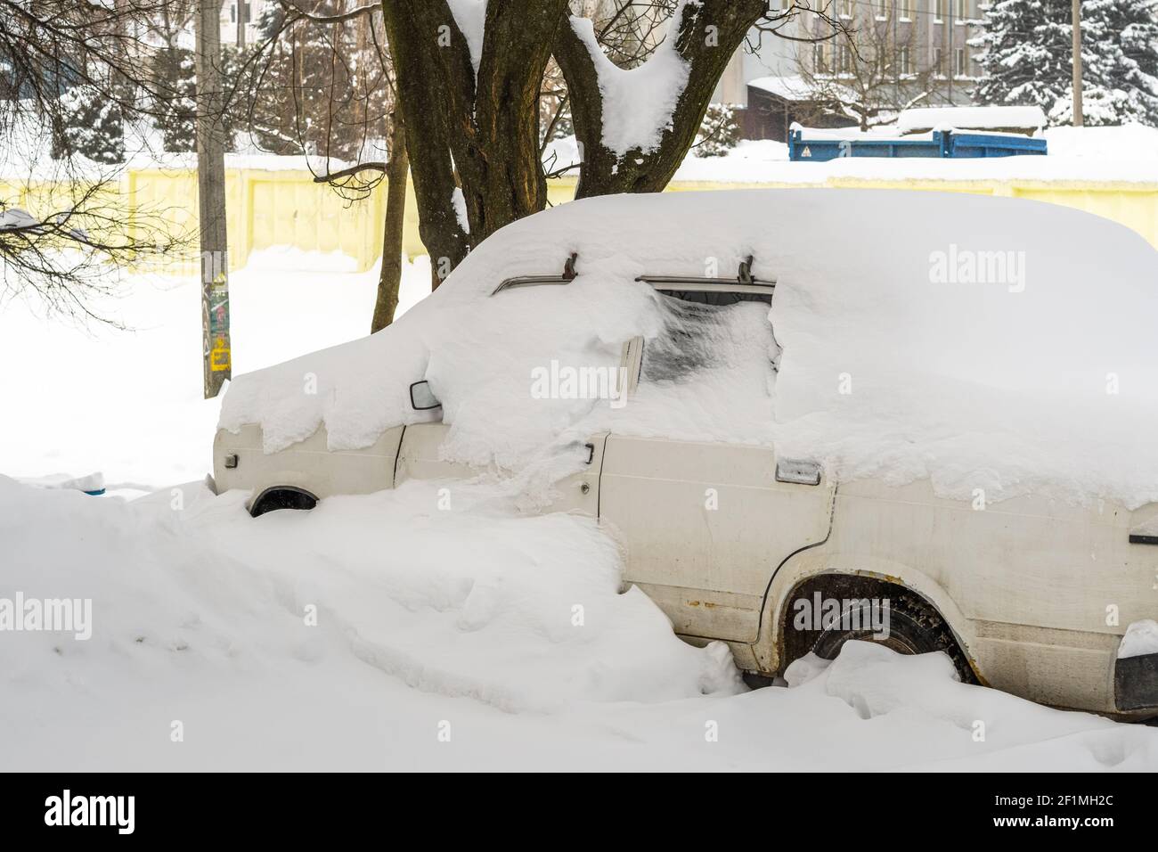 City street after blizzard. Stuck cars under the snow and ice. Buried ...