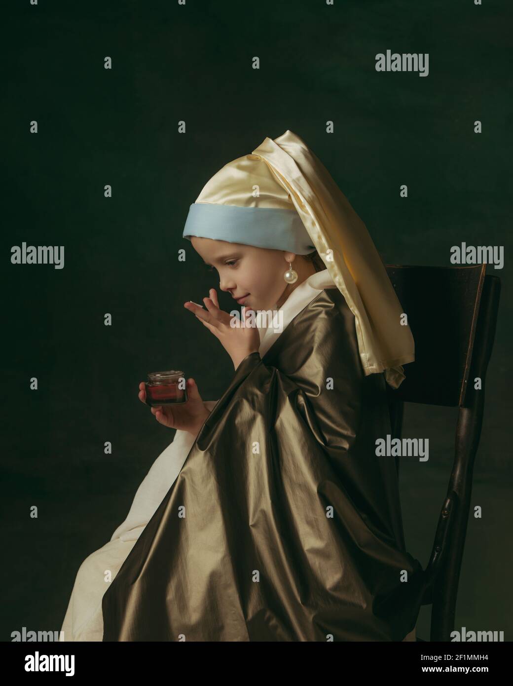 Using cosmetical face cream. Medieval little girl as lady with a pearl ...