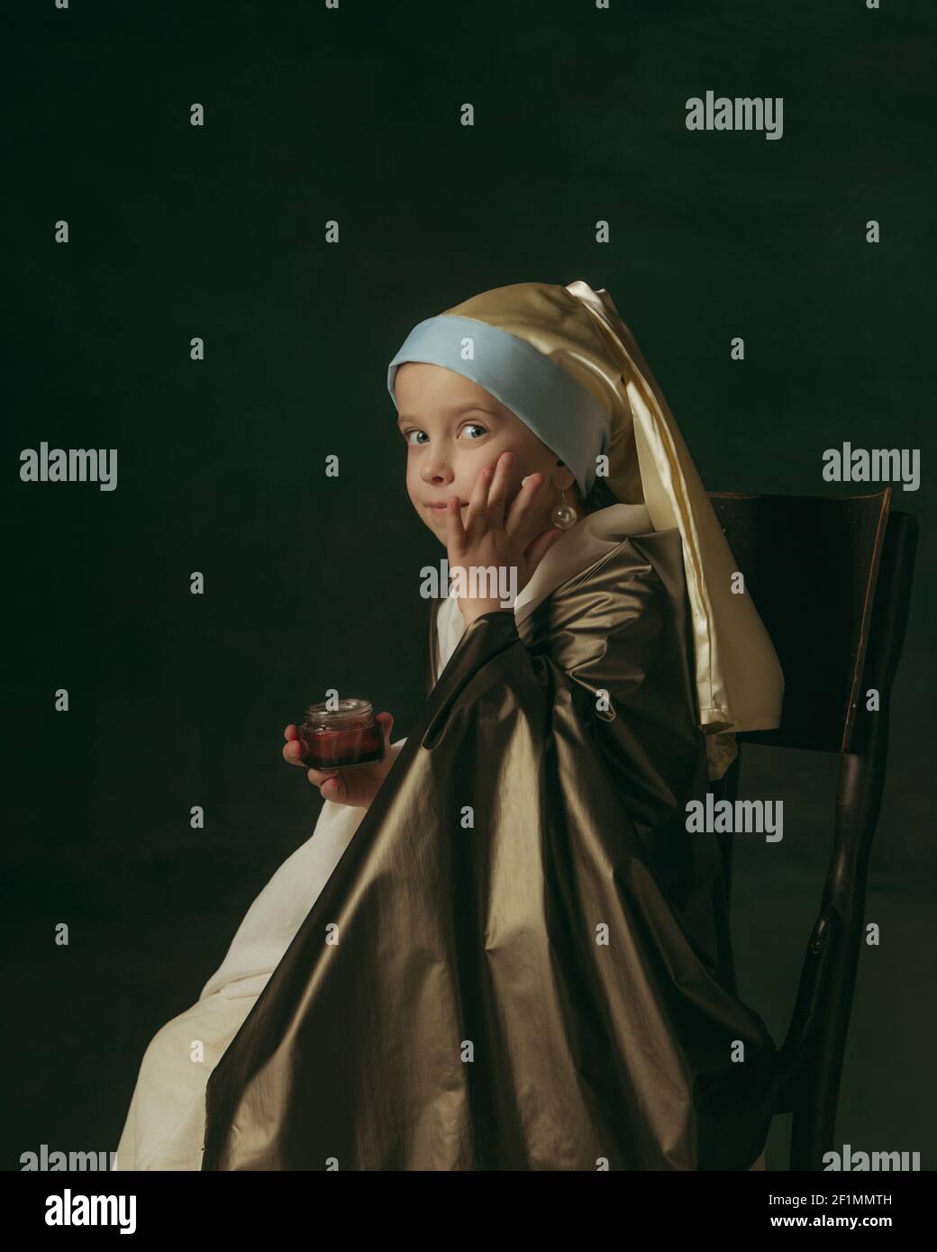Using cosmetical face cream. Medieval little girl as lady with a pearl ...
