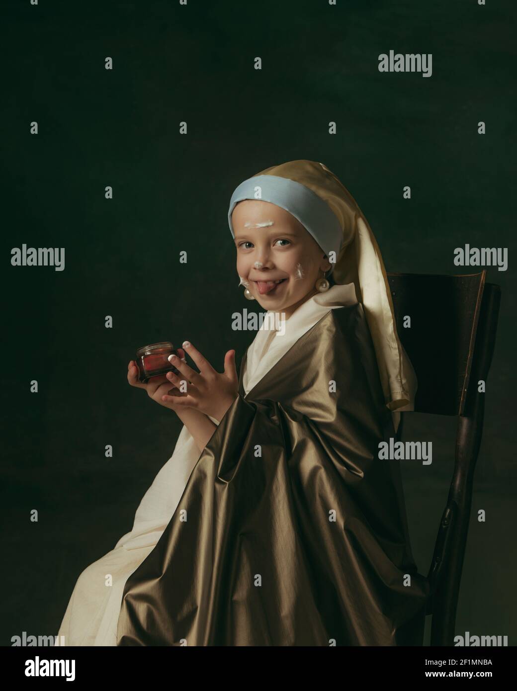 Using cosmetical face cream. Medieval little girl as lady with a pearl ...